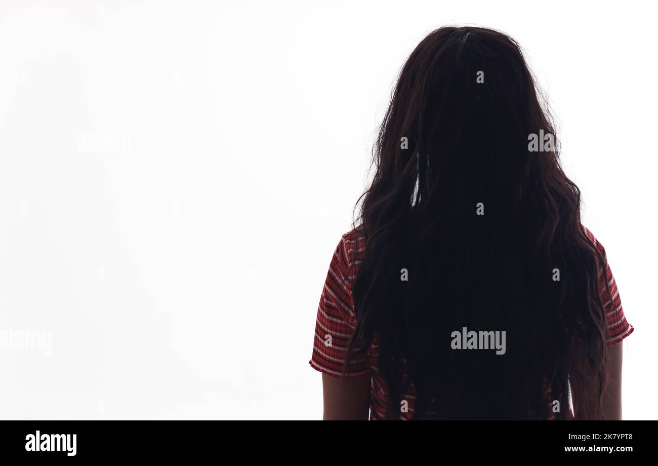 Rear view of unrecognisable young woman with long dark hair back turned ...