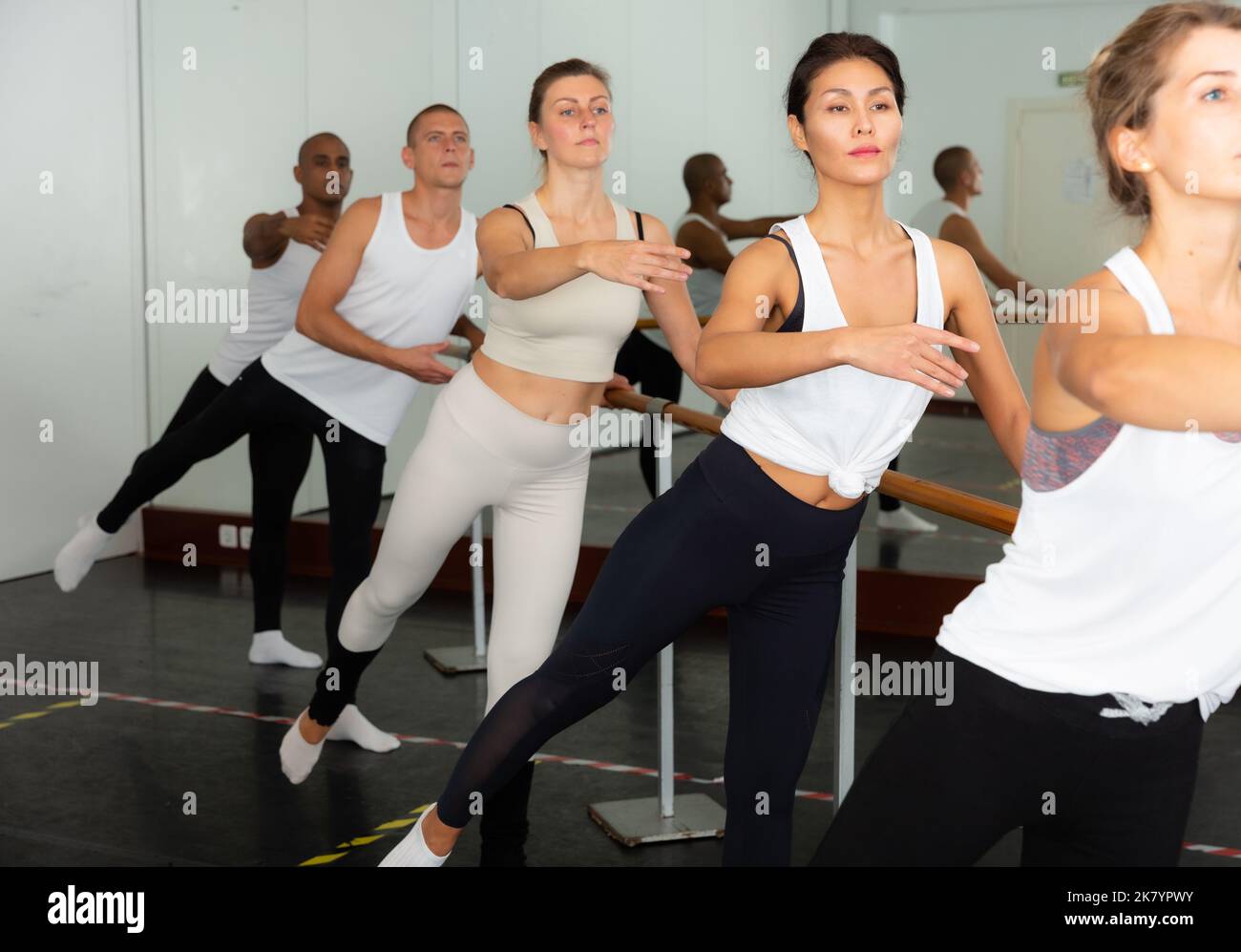 people doing exercises on stretching ballet barre Stock Photo - Alamy