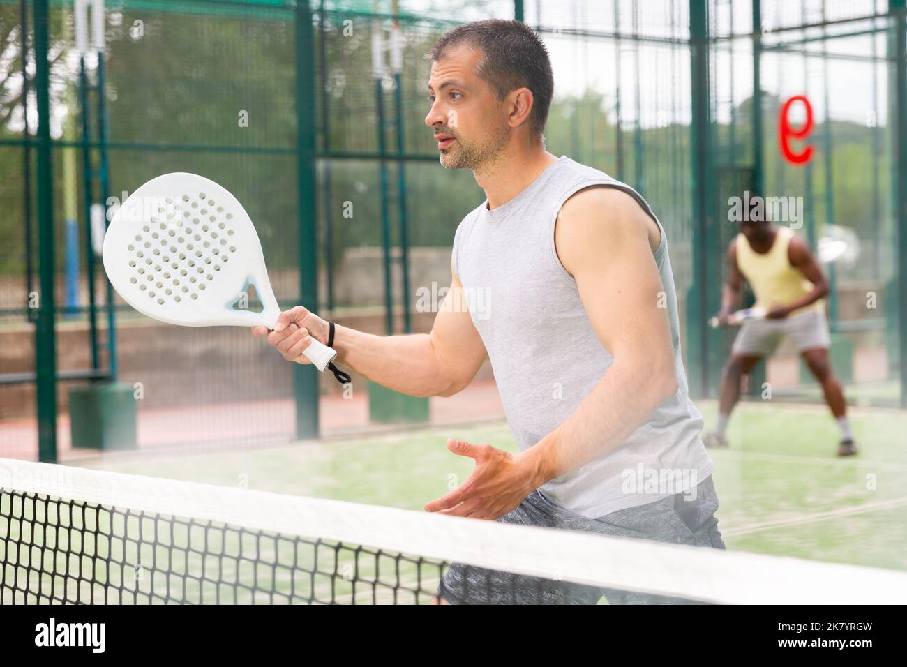 Male players playing padel in a padel court outdoor behind net Stock ...