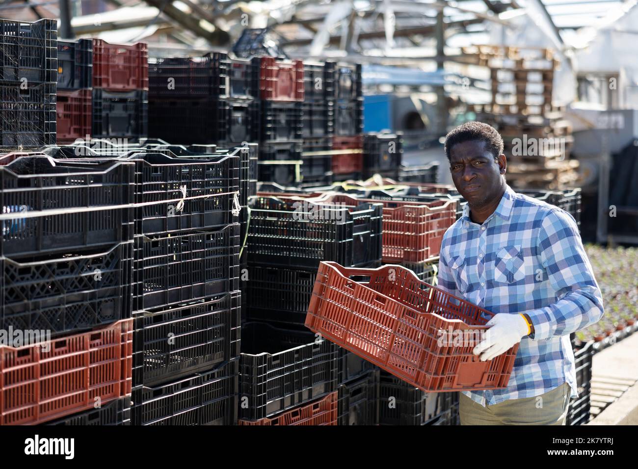Worker stacking crates in outdoors warehouse Stock Photo - Alamy