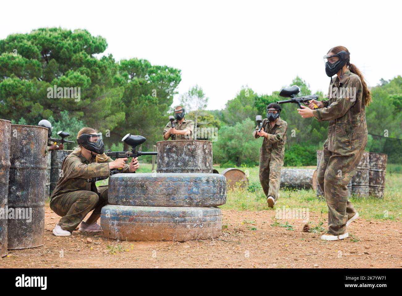 Two active opposing teams with guns playing paintball Stock Photo - Alamy