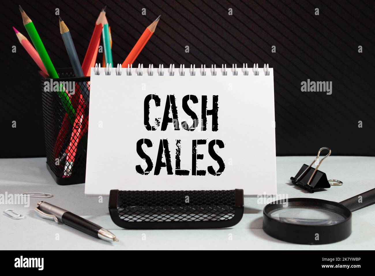 On the table there is a red marker and a white paper tablet on which ...