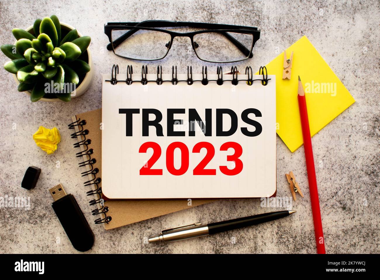 Text TRENDS 2023 on white paper between white and brown spiral notepads ...