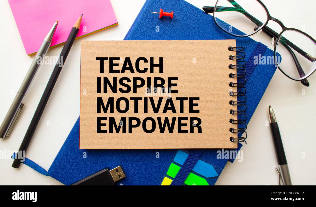 Open notebook with text Teach inspire motivate empower on wooden ...