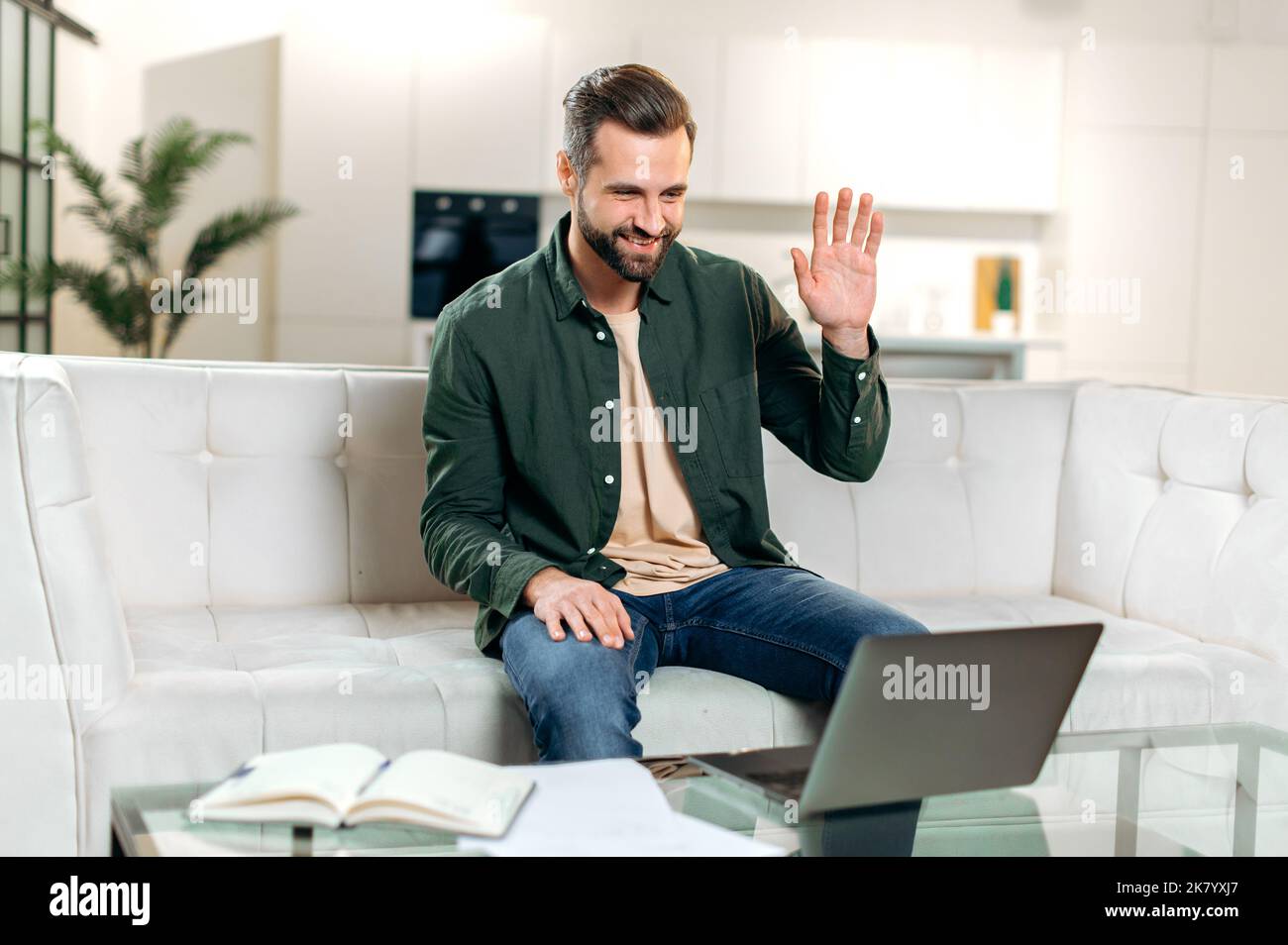 Distant conversation. Positive caucasian man, freelancer, sits on a ...