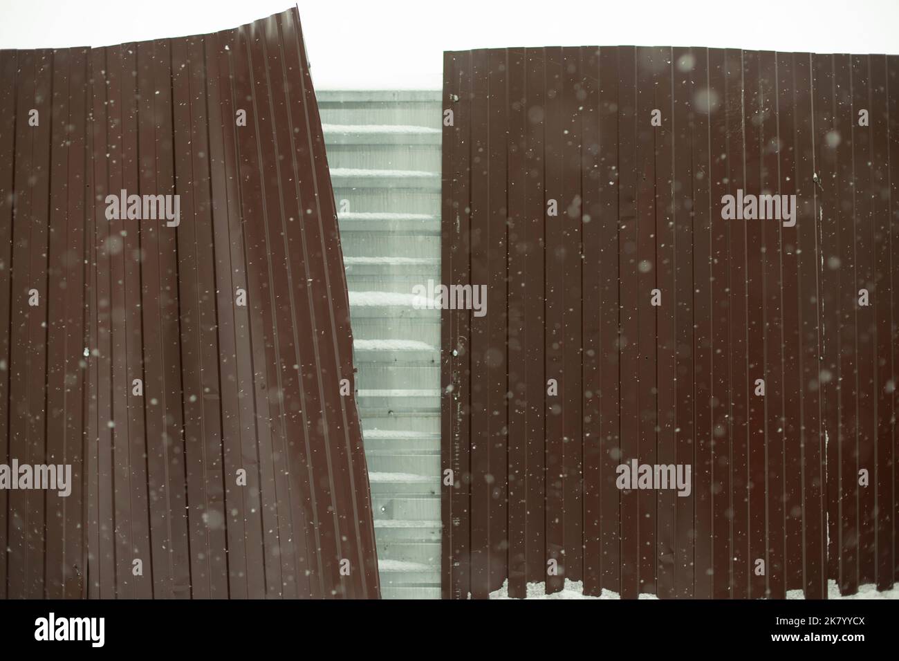 Fence broken. Steel profile in wind. Fence in winter is torn away from ...