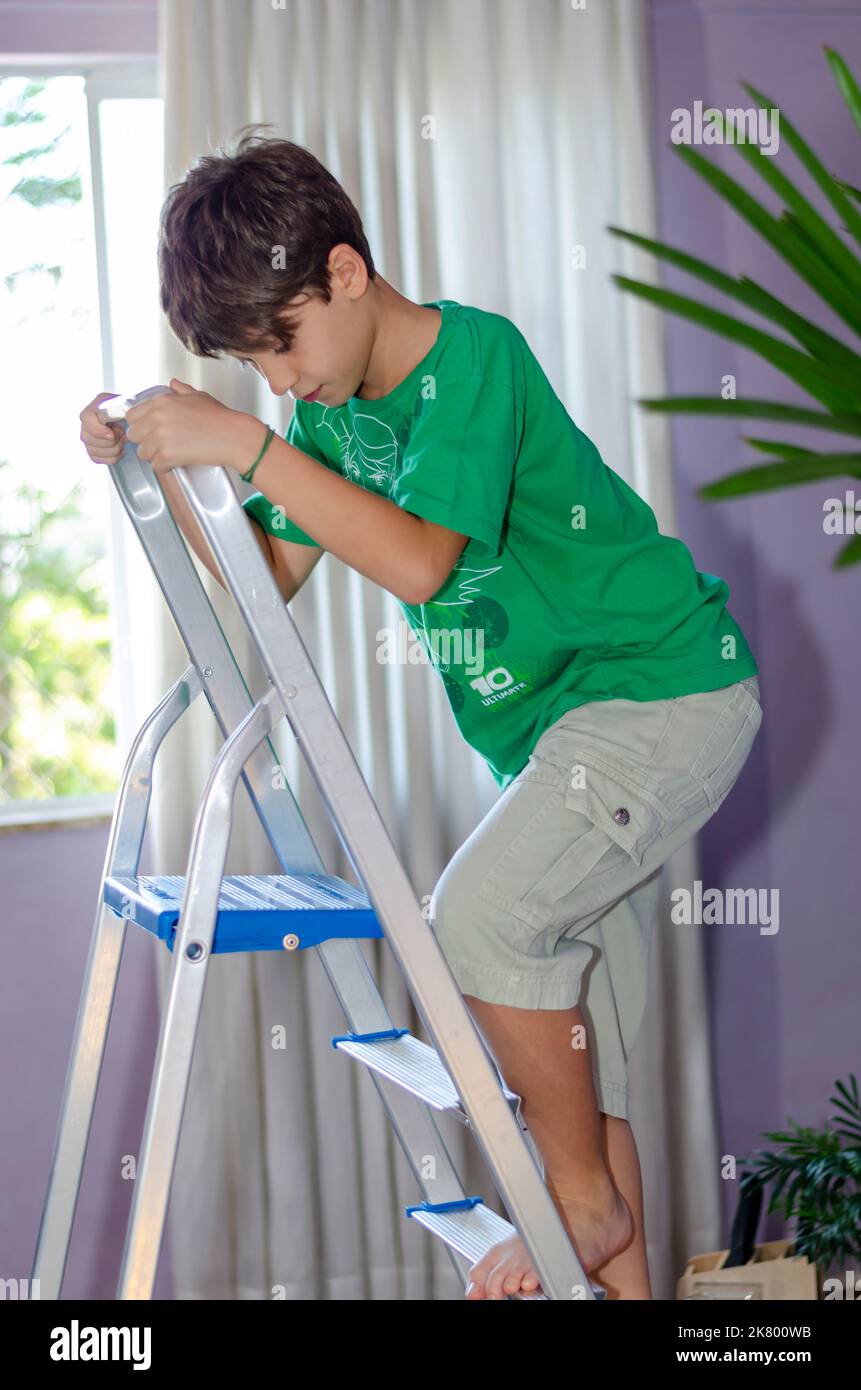 Portrait of a child climbing a stainless steel ladder. Skill at home ...