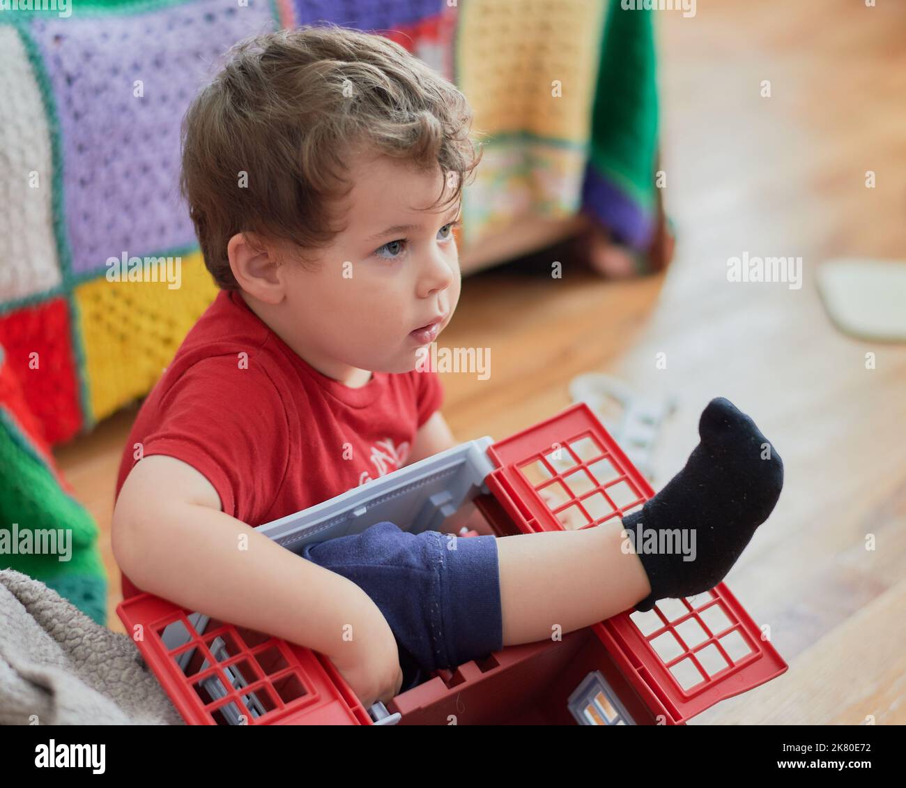 young boy is tangled up inside his toy Stock Photo - Alamy