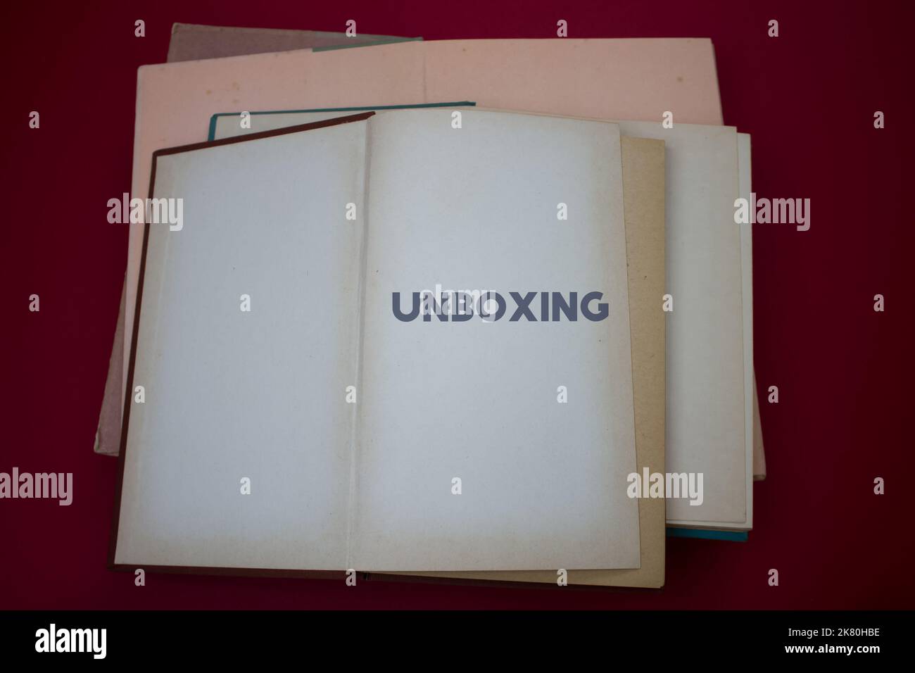Unboxing word in opened book with vintage, natural patterns old antique ...