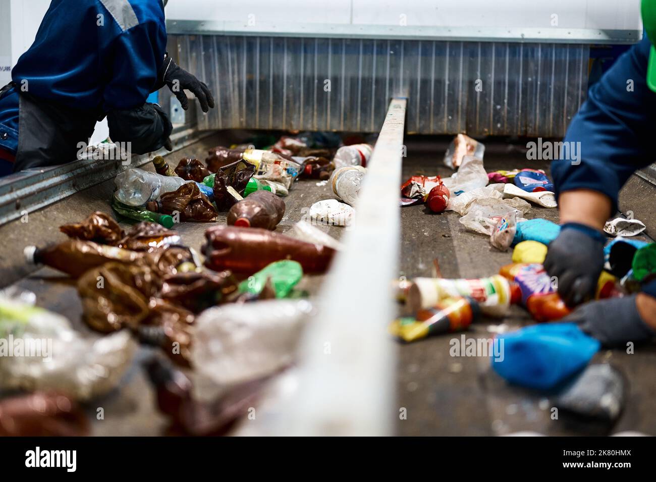 Worker sorts trash on conveyor belt at waste recycling plant Stock Photo - Alamy