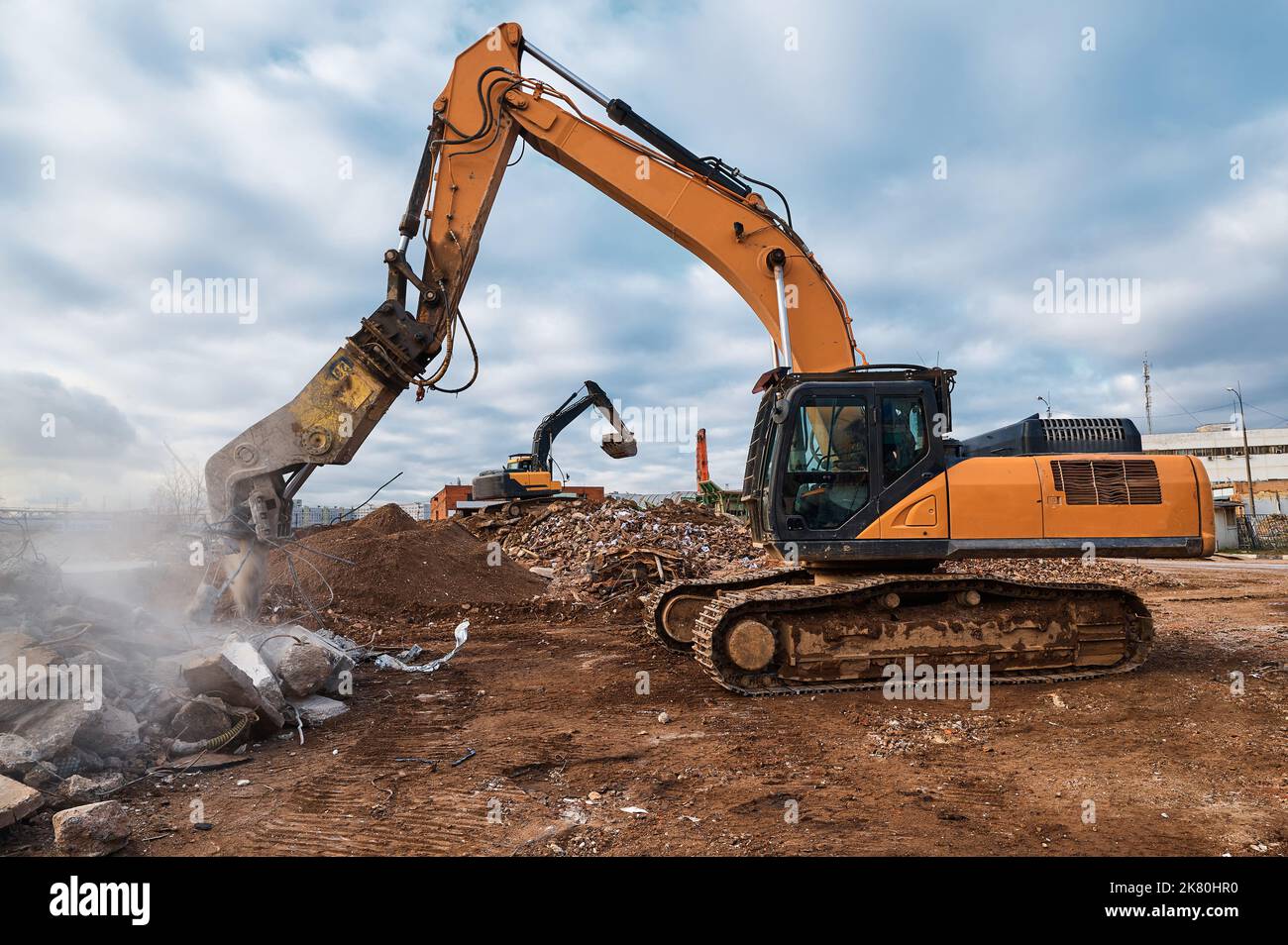 Excavator with hydraulic press breaks concrete leftovers Stock Photo - Alamy