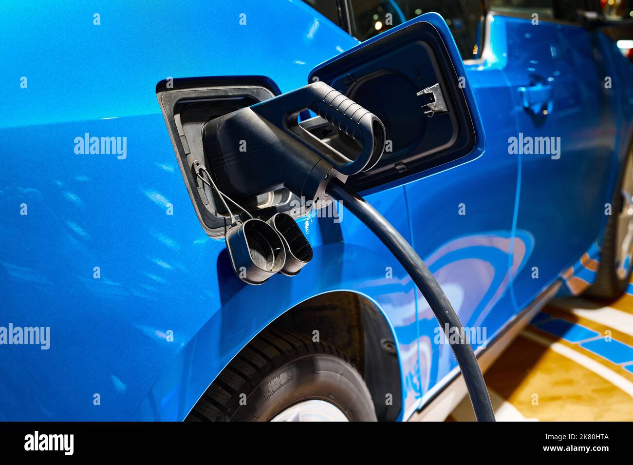 Charging electric blue automobile with plug at power station Stock ...