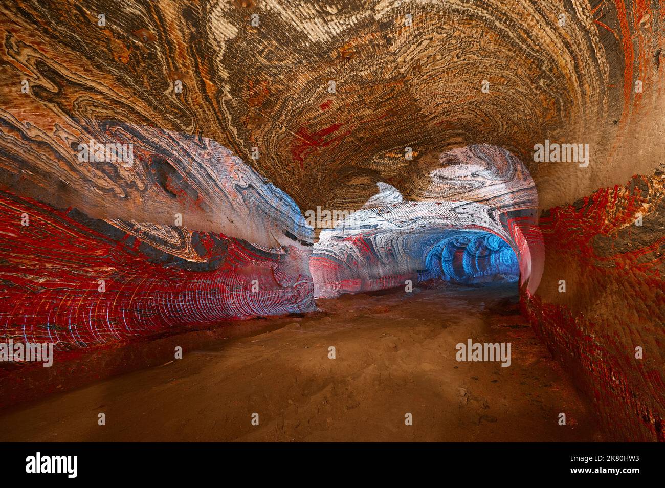 Outgoing tunnel of salt quarry with red patterns on walls Stock Photo ...