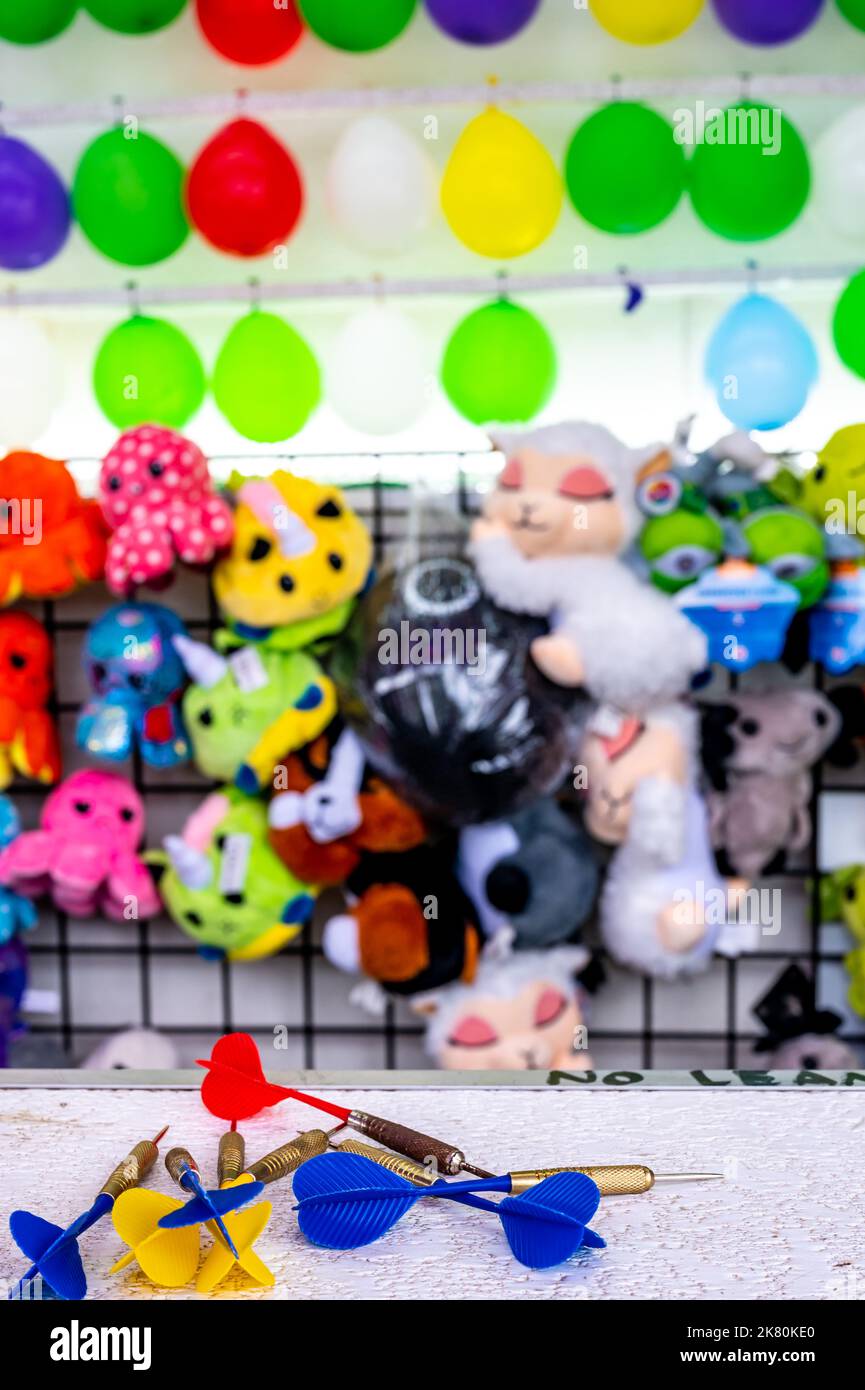 selective focus on darts sitting on a ledge with a wall of balloon ...