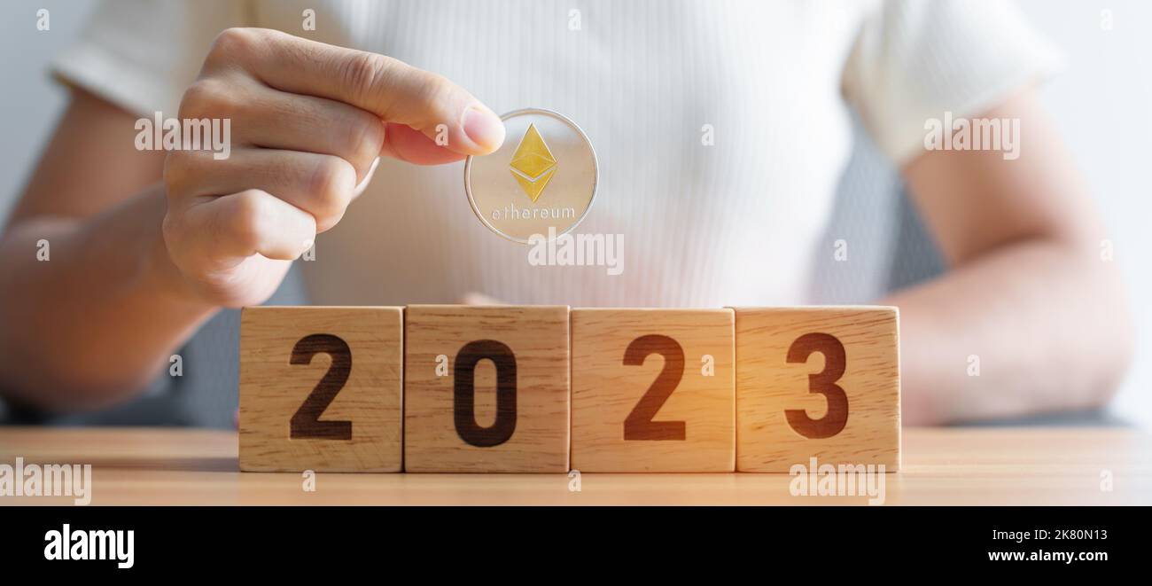 hand holding silver Ethereum or ETH cryptocurrency over 2023 Year ...