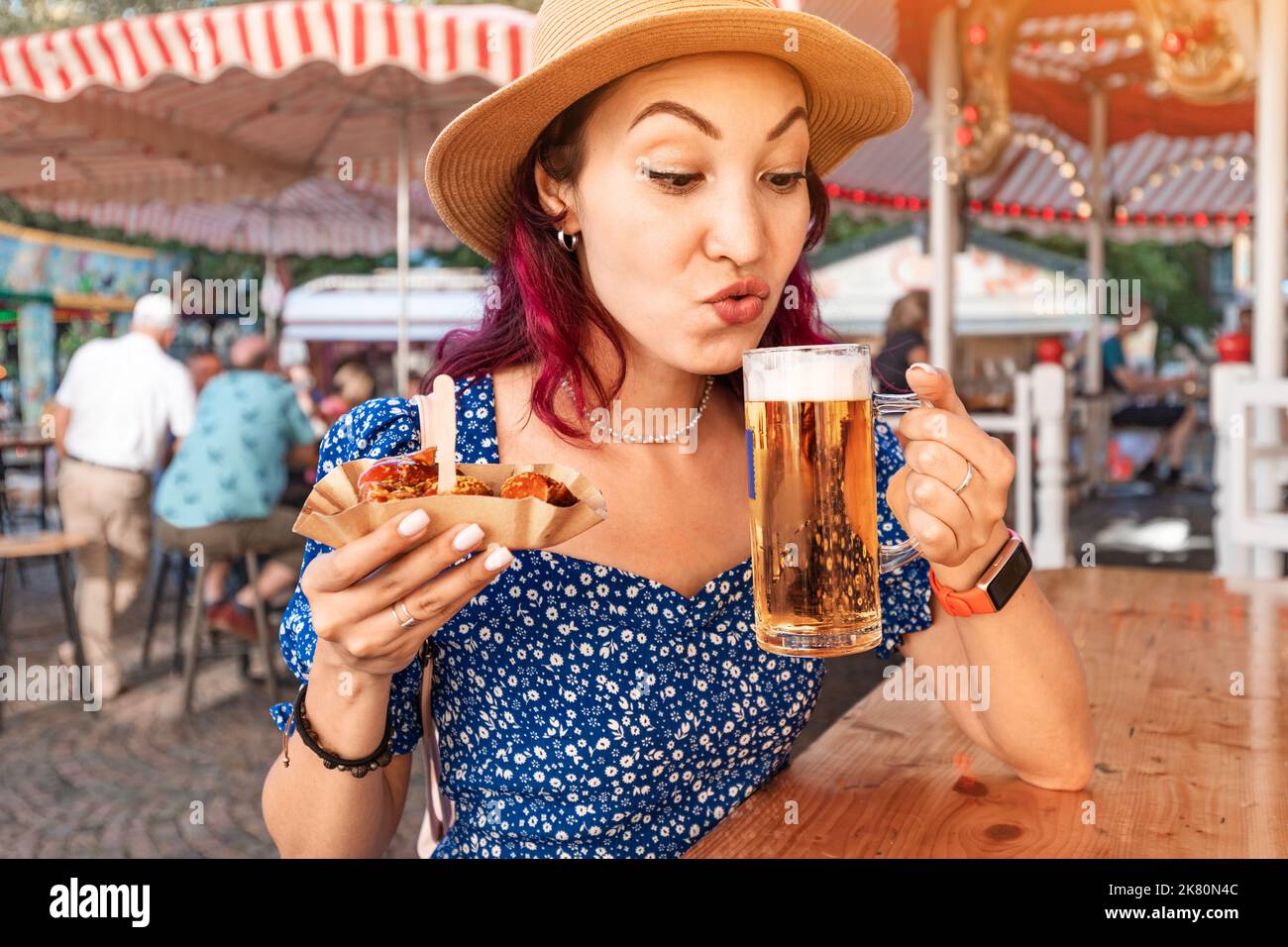Happy and funny girl drinking beer and eating traditional german ...