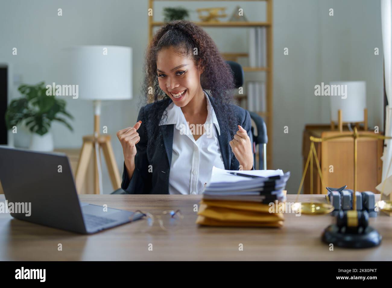 female African Americans lawyer showing joy while using a computer ...
