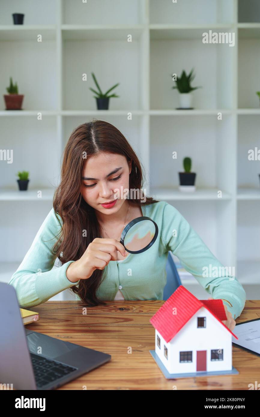 customer holding a magnifying glass to look at a house model inspection Stock Photo - Alamy