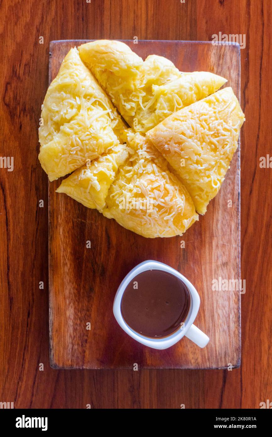 Filipino ensaymada bread topped with cheese and paired with hot ...