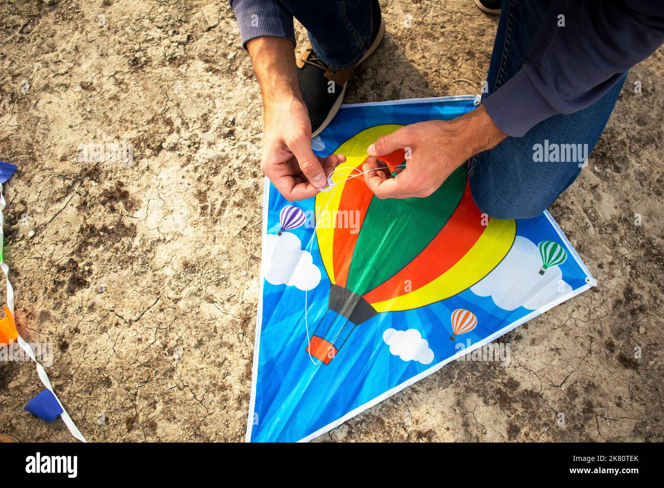 a man ties a rope on a children's kite. tying a kite. preparing for the ...