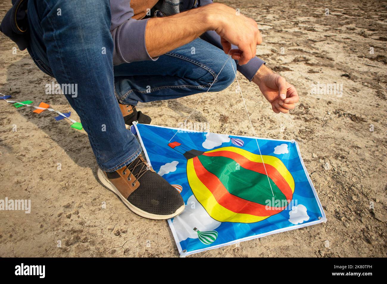 a man ties a rope on a children's kite. tying a kite. preparing for the ...