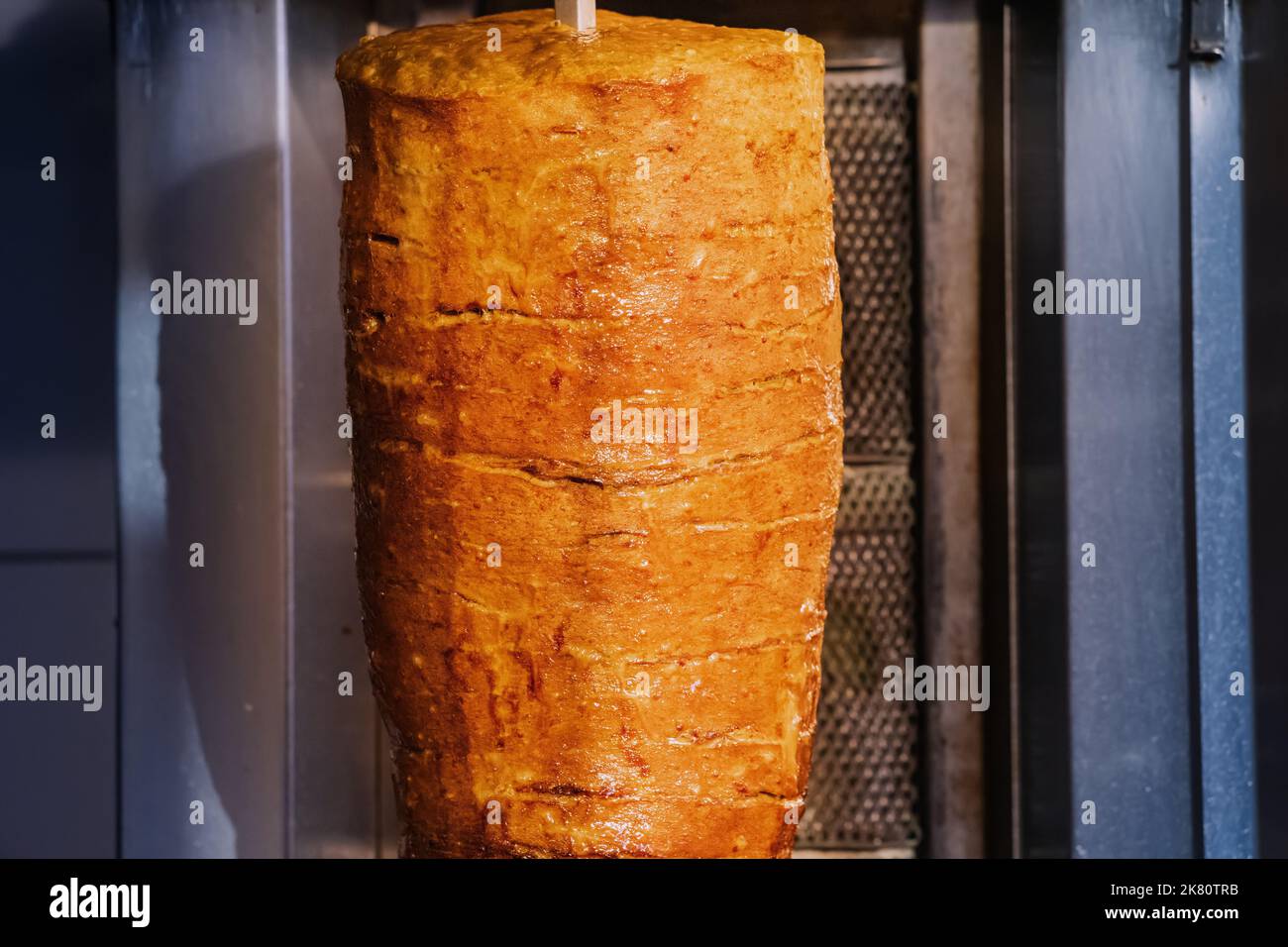 doner kebab on a spit with toasted slices of meat from the grill in a ...
