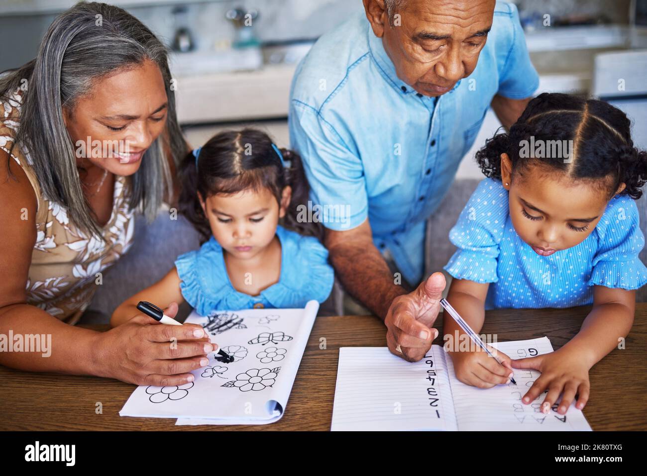 Children, education and homework with a girl, sister and grandparents ...