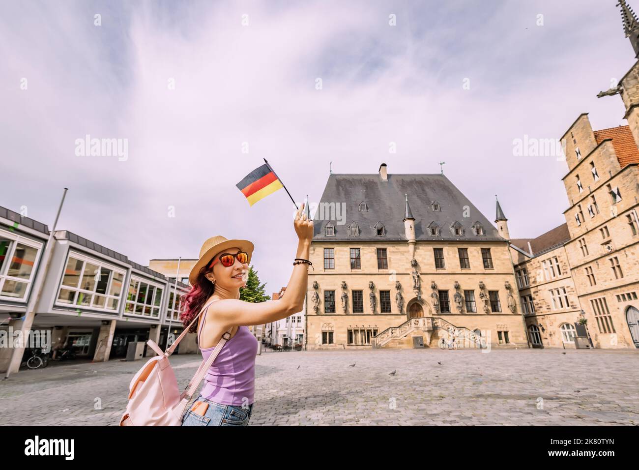 A young happy Asian girl with a German flag at the City Hall Rathaus in ...