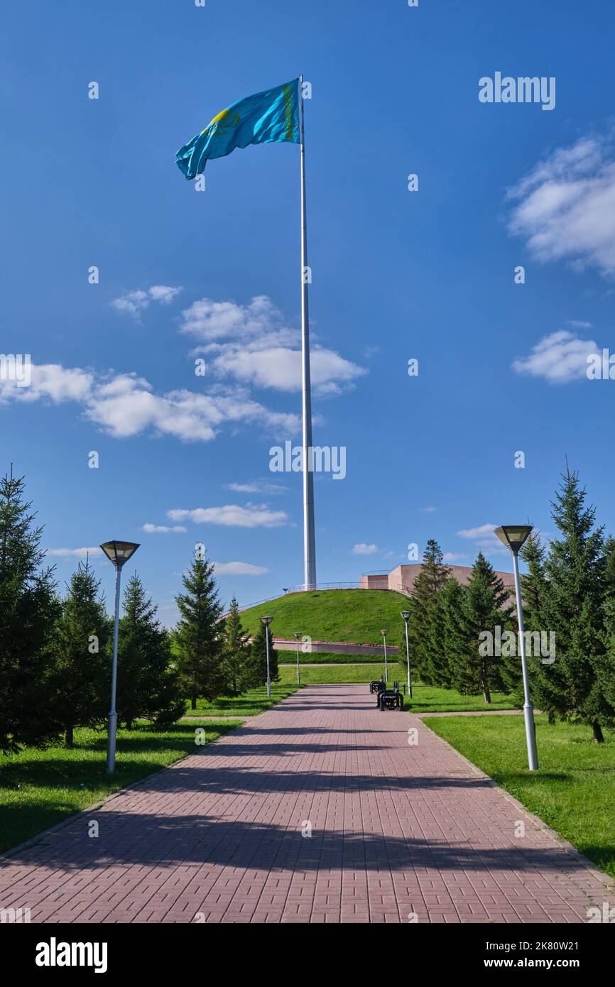 A giant, blue Kazakh flag, proudly flying on a tall flagpole in Central ...