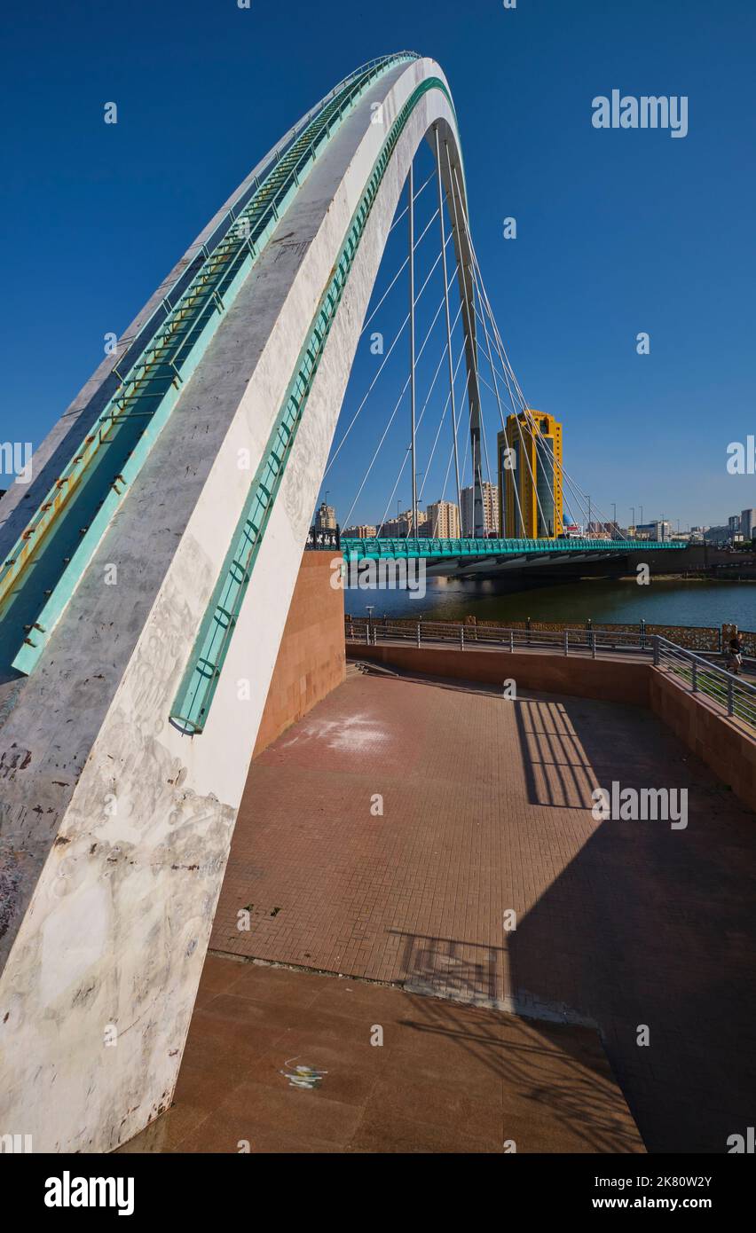 A view of the modern, curved, cable suspended bridge over the Ishim ...
