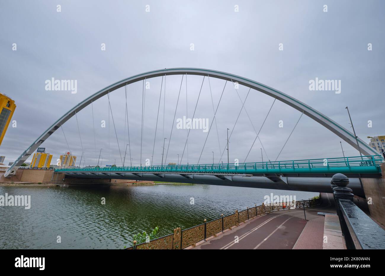 A view of the modern, curved, cable suspended bridge over the Ishim ...