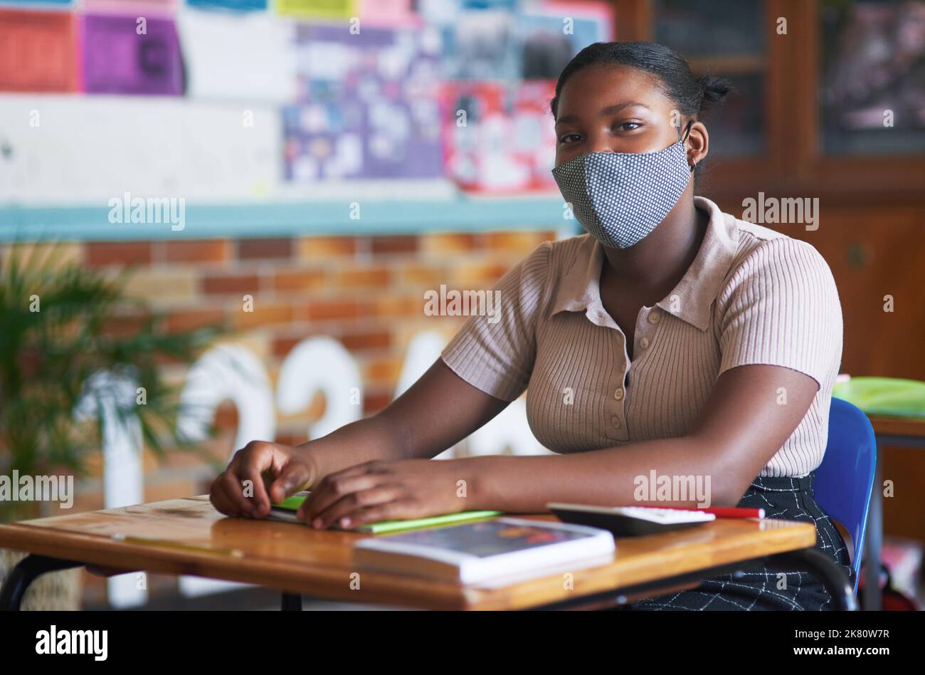 Learning through Covid times. a young girl sitting alone in her ...