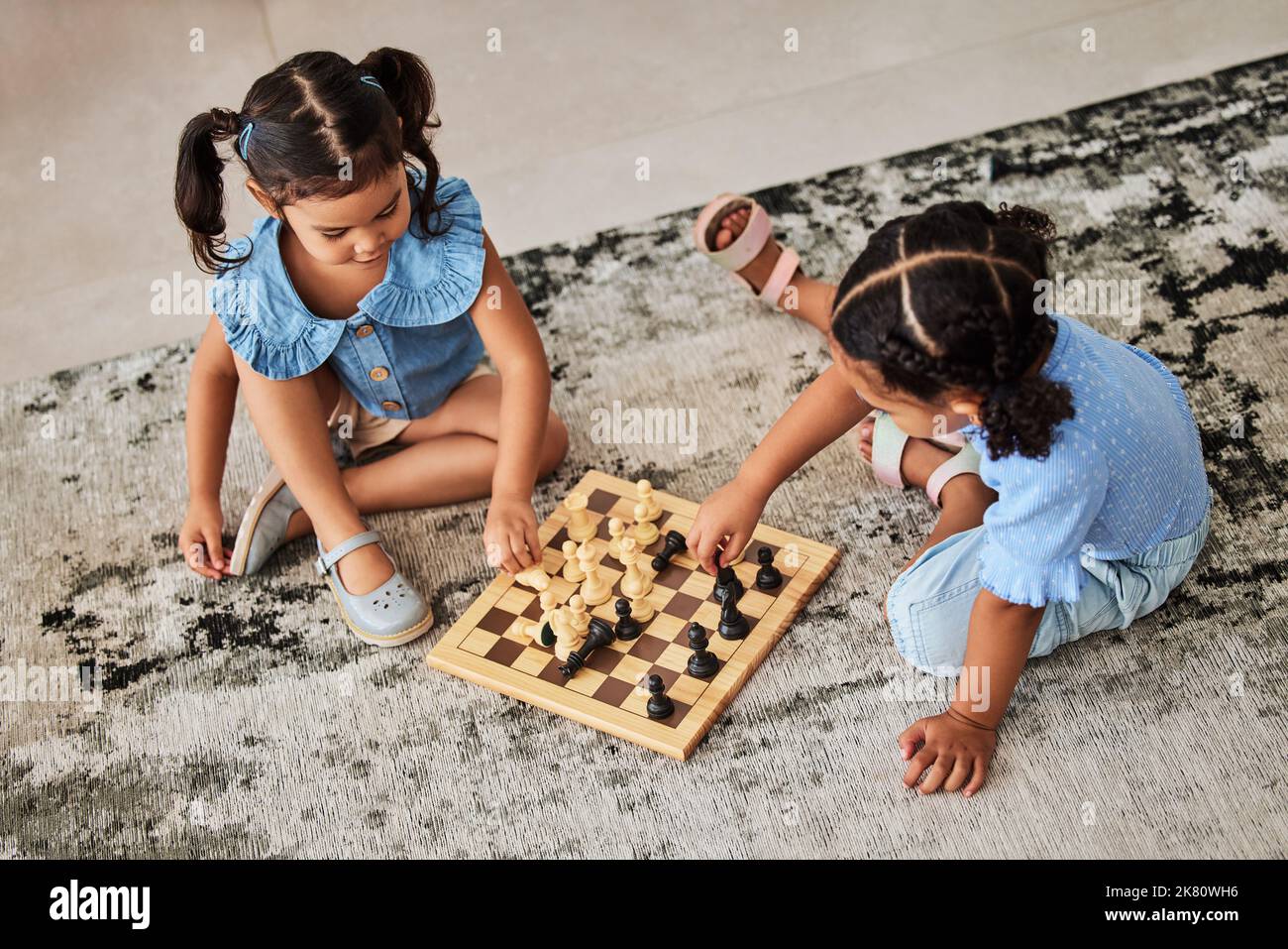 Girl children, knowledge fun and chess game on a living room carpet for ...