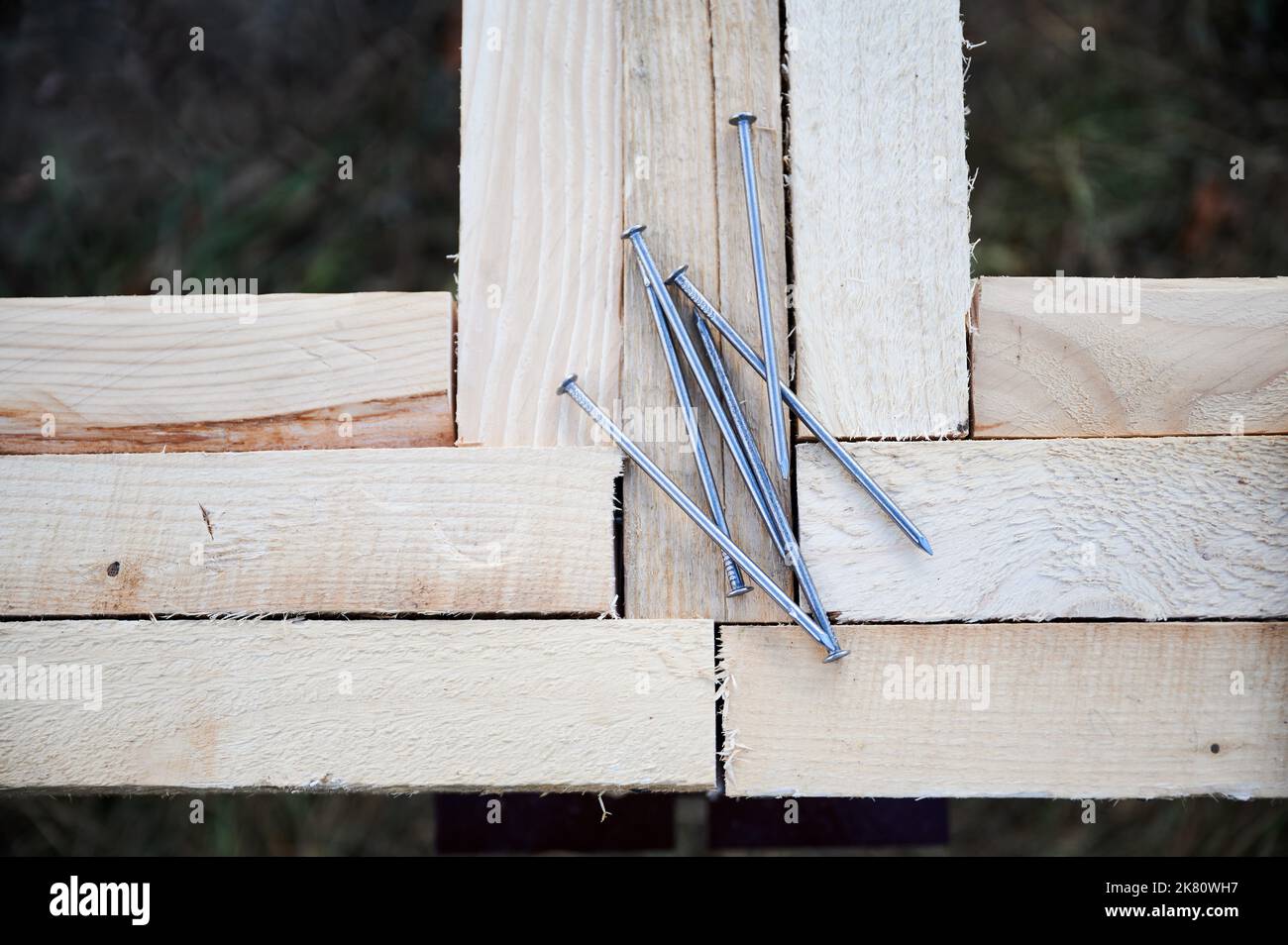 Close up of nails laying on wooden pile foundation for future frame ...