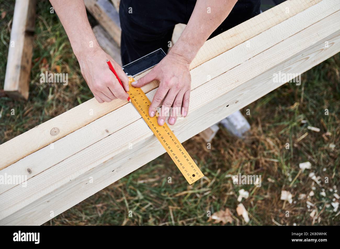 Man worker building wooden frame house on pile foundation. Close up ...