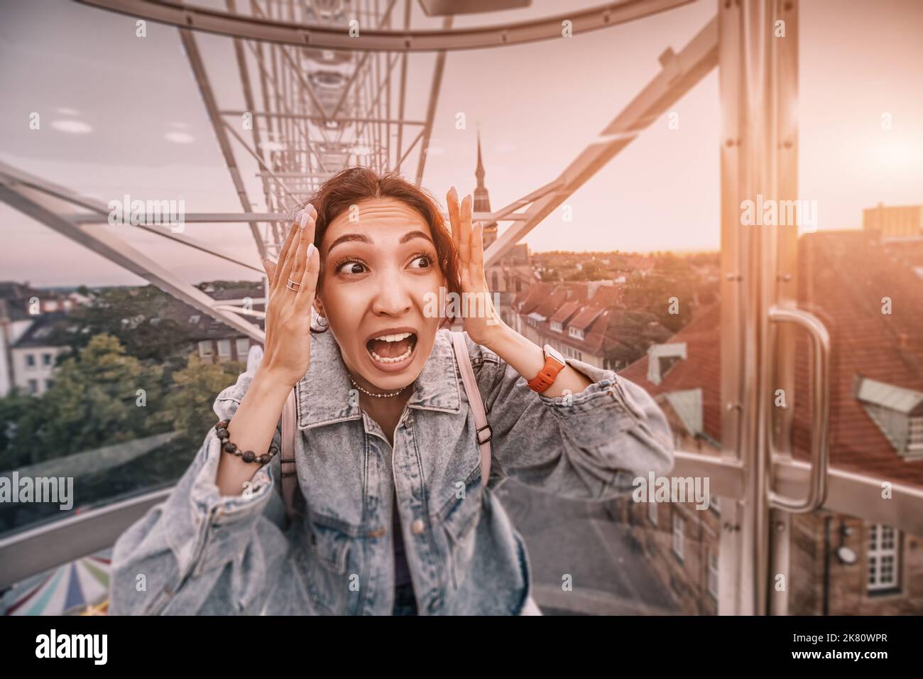 Afraid girl in the Ferris wheel is experiencing a panic attack due to ...