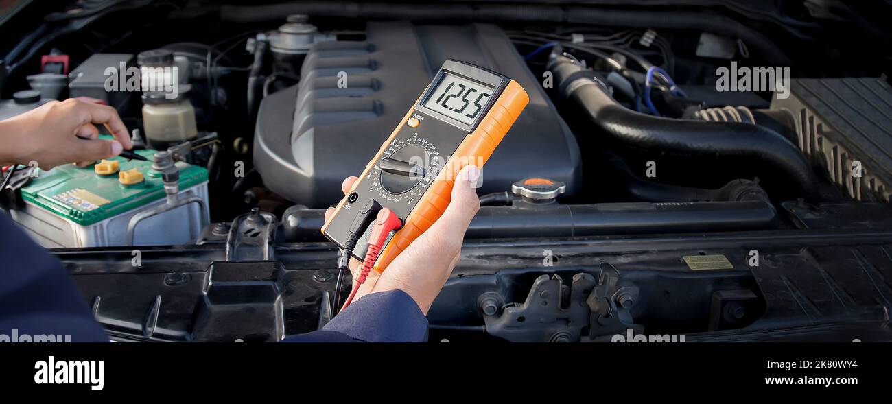 A technician is checking the car battery for availability Stock Photo ...