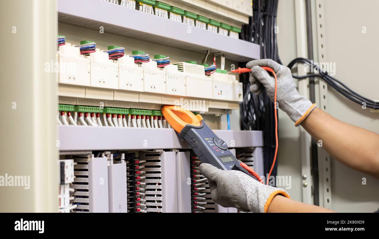 Electrical engineer tests the operation of the electric control cabinet ...