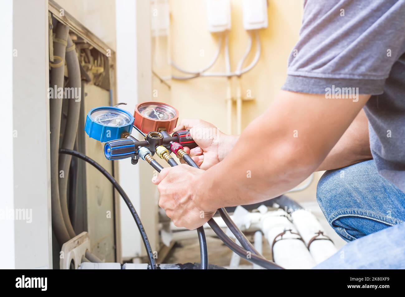 Air repair mechanic using measuring equipment for filling industrial ...