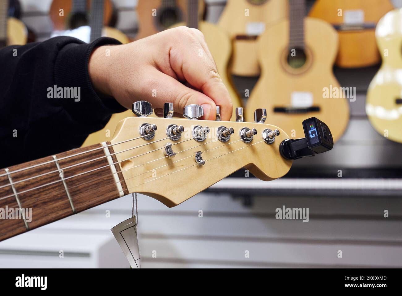 Tuning a guitar in a music store Stock Photo - Alamy