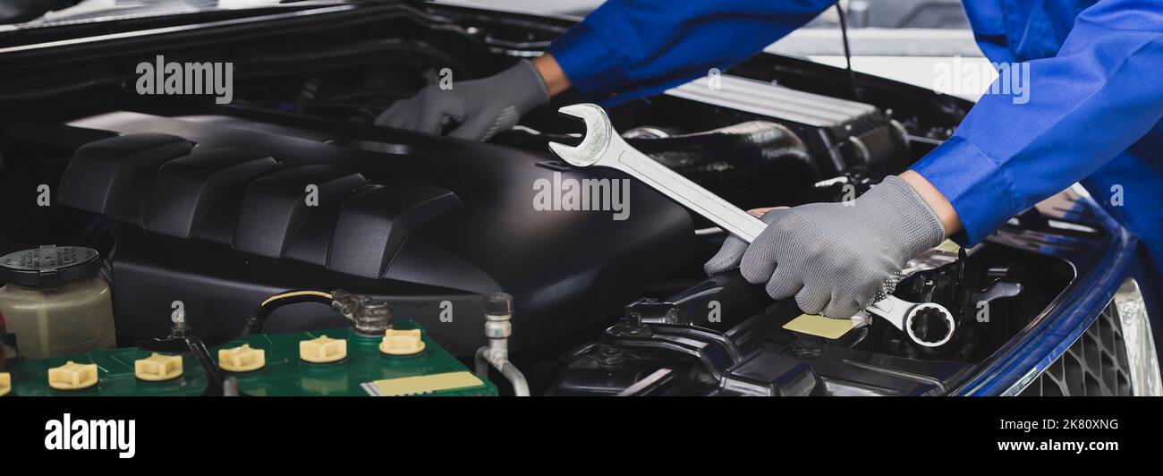 Mechanic works on the engine of the car in the garage.Concept of car ...