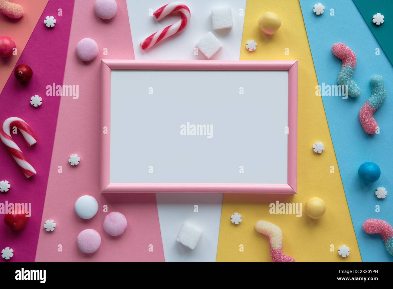 Blank pink white frame on layered colored paper. Assorted sweets ...