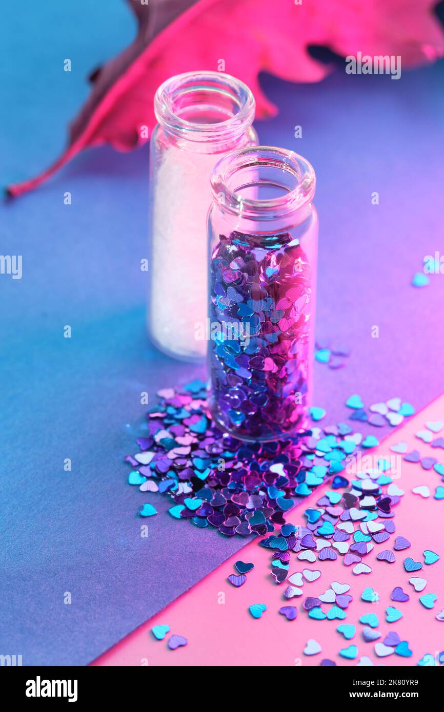 Neon colored powder glitter products on pink sparkling background ...