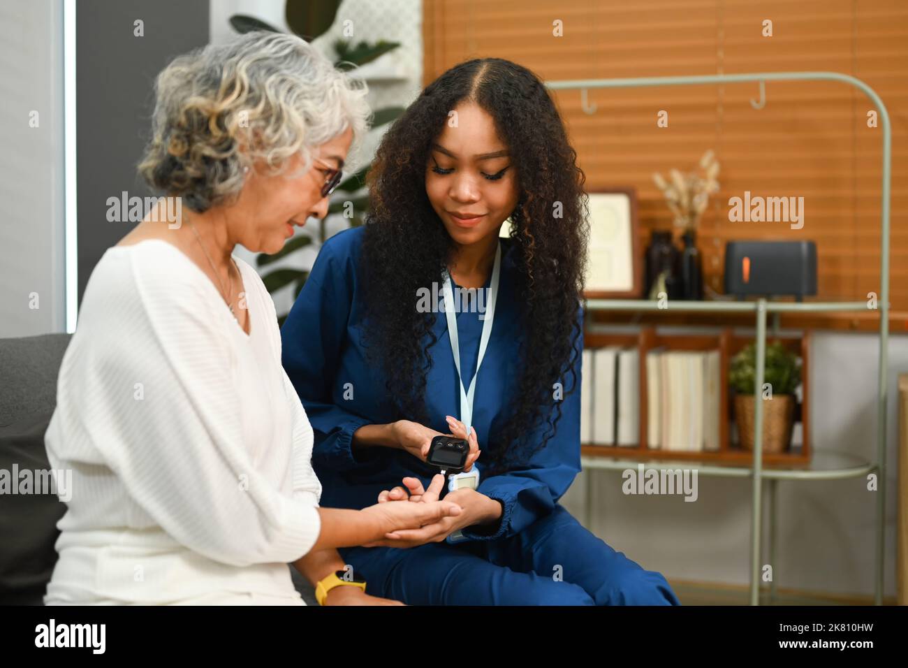 Senior diabetic woman having check up blood glucose levels from a ...