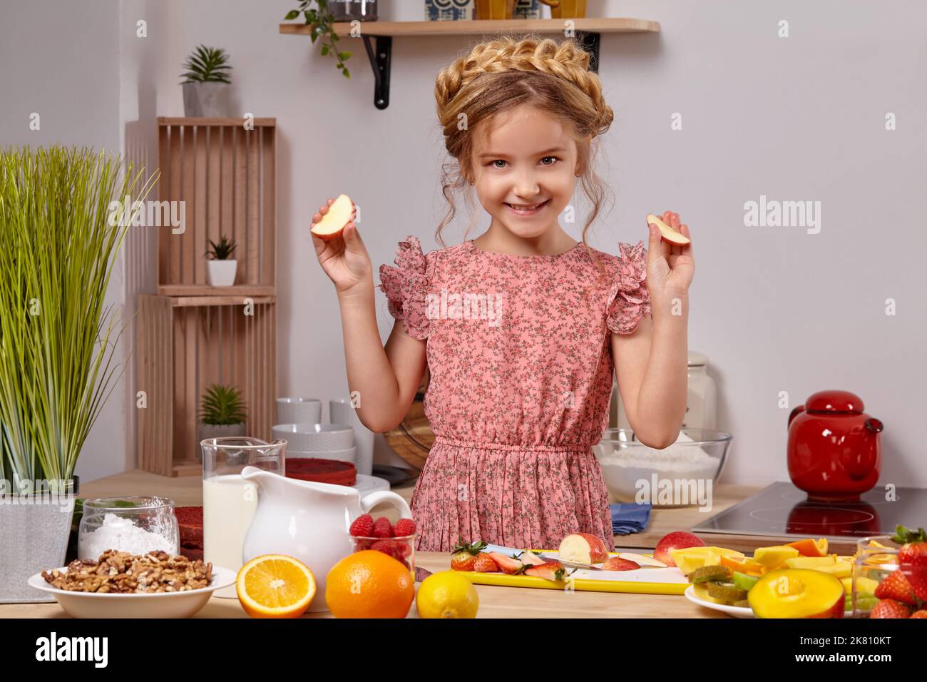 Cute beautiful girl with a modern hairstyle is cooking at a kitchen ...