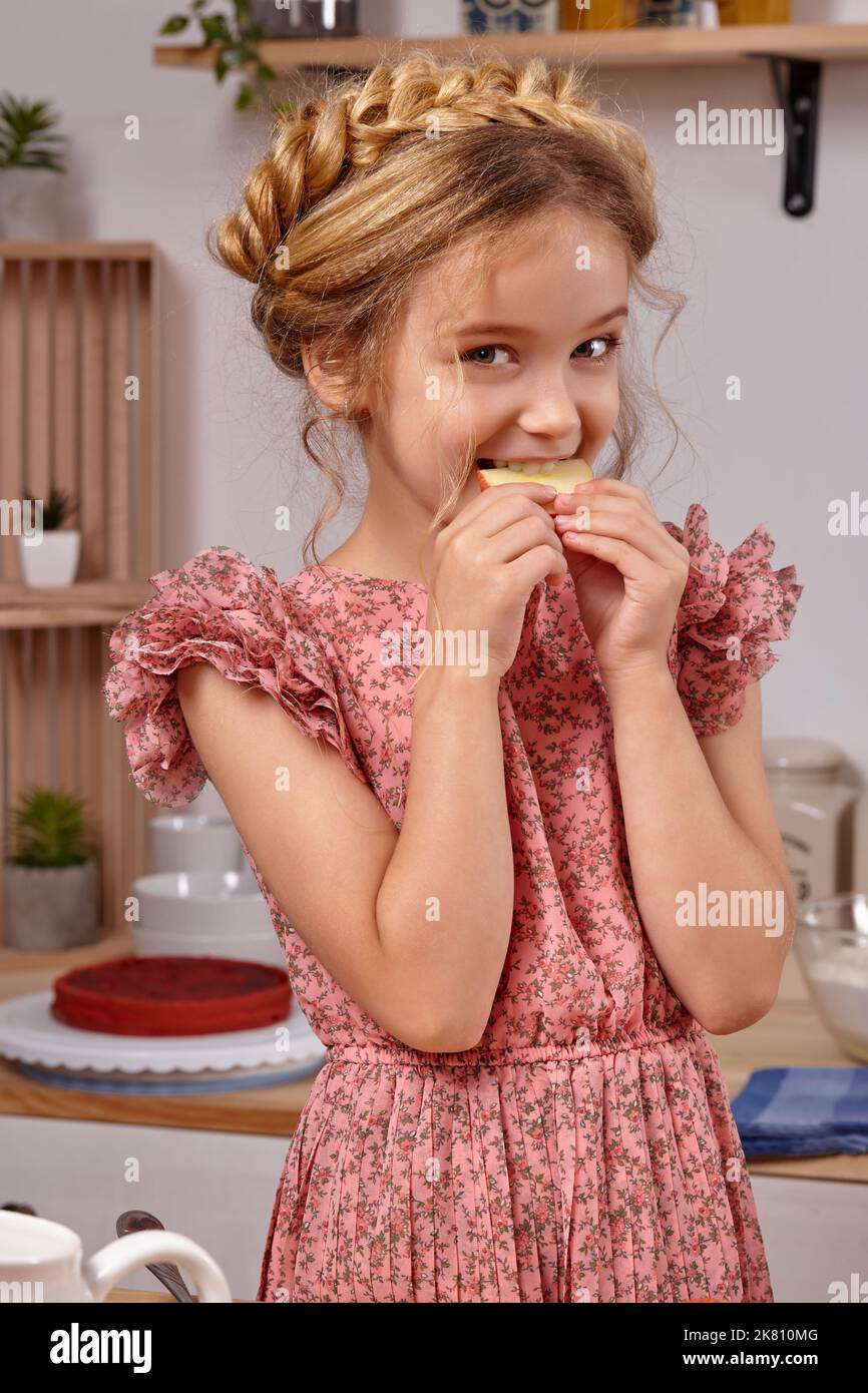Cute beautiful girl with a modern hairstyle is cooking at a kitchen ...