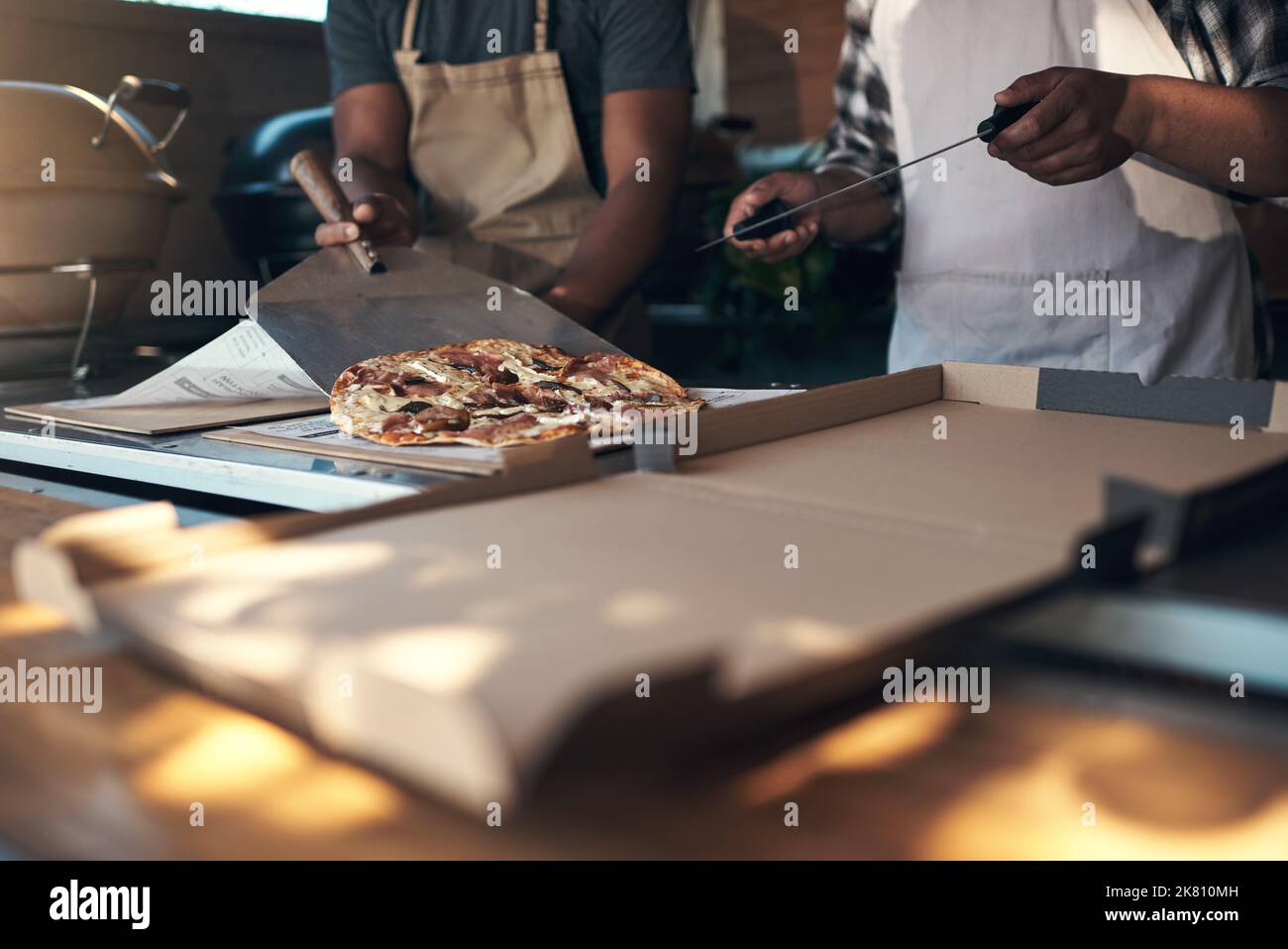 One hot pizza, coming right up. two unrecognizable men standing and ...