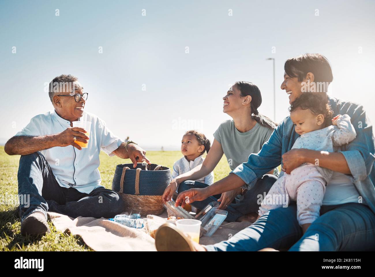 Picnic, juice and big family relax on grass for summer holiday, outdoor ...