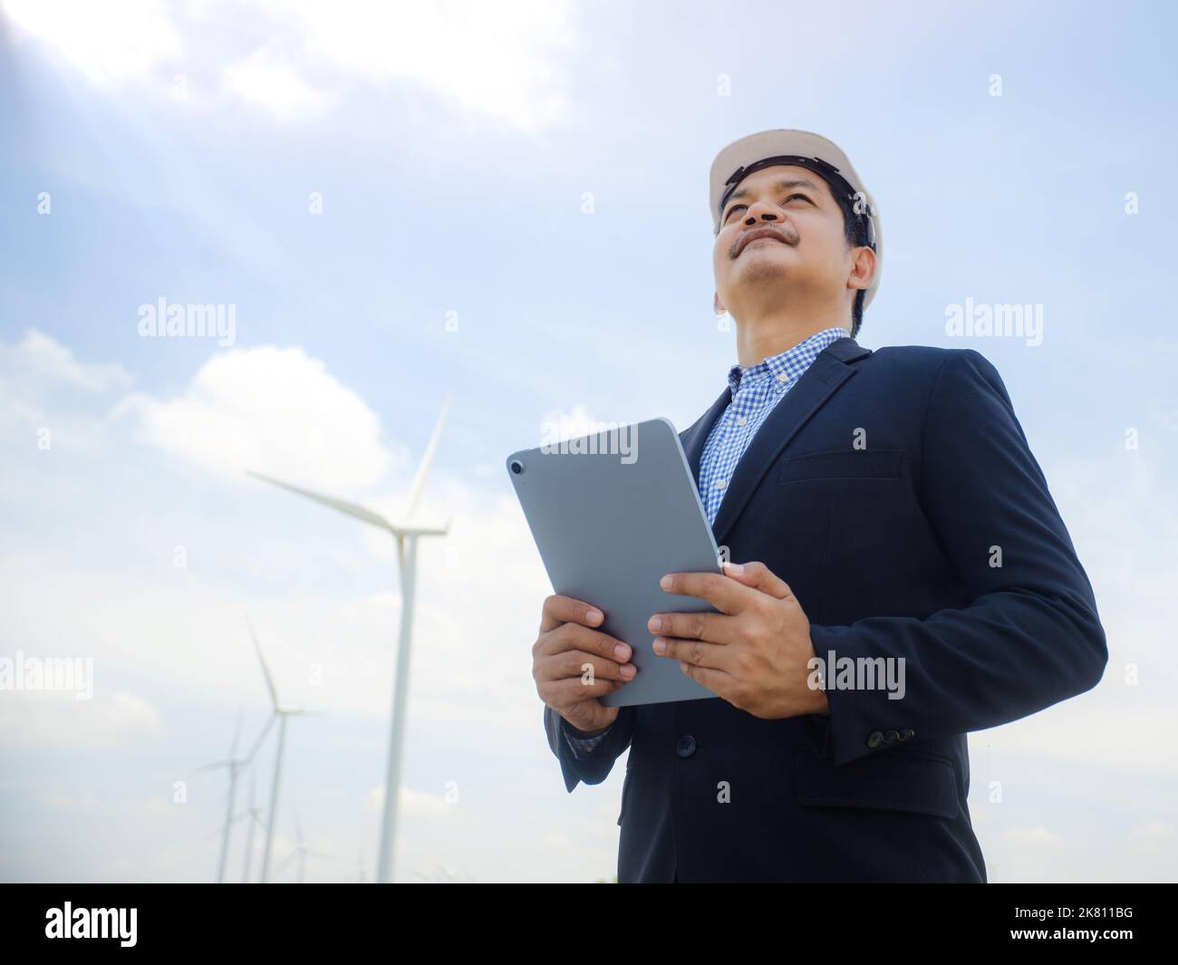 Engineer man manager in suit stand holding tablet front the wind ...