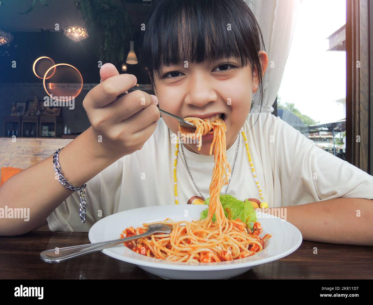 Cute asian little girl eating spaghetti bolognese with smile and happy ...